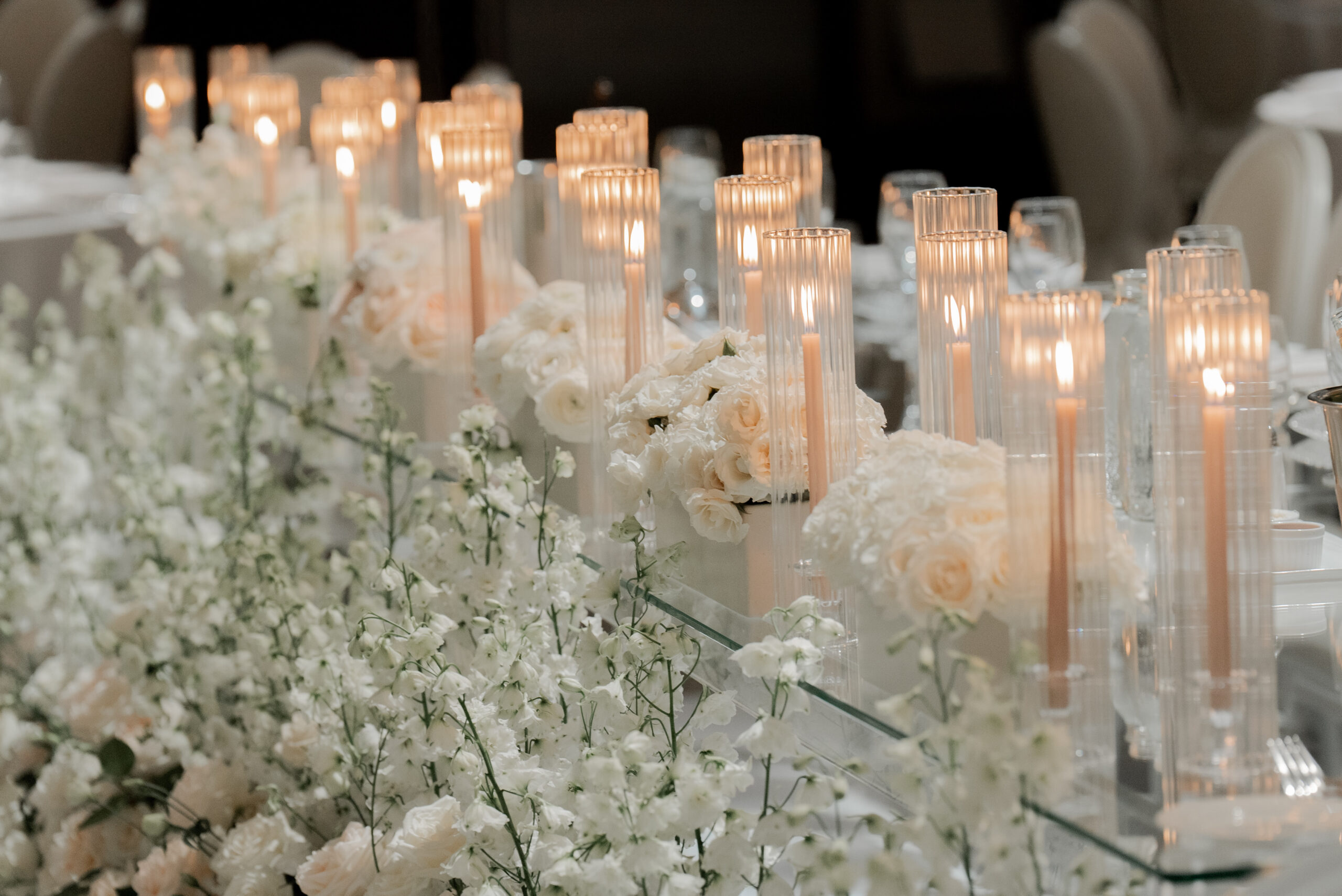 A formal garden wedding at Château Le Parc showcases tall, lit candles ...