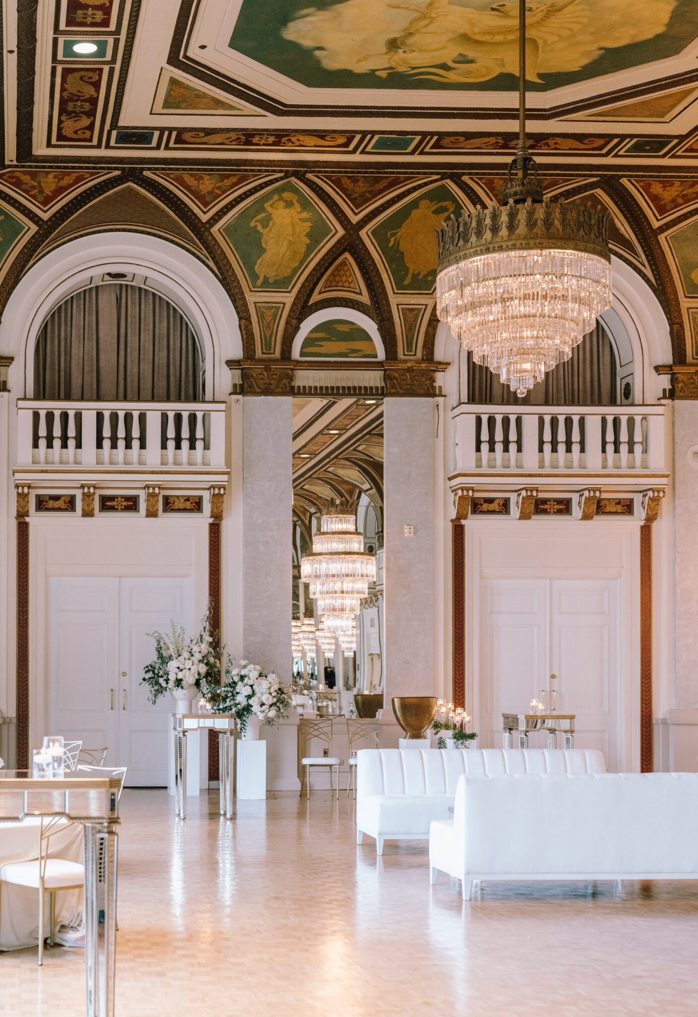 Elegant ballroom with ornate ceiling, large chandelier, white double ...
