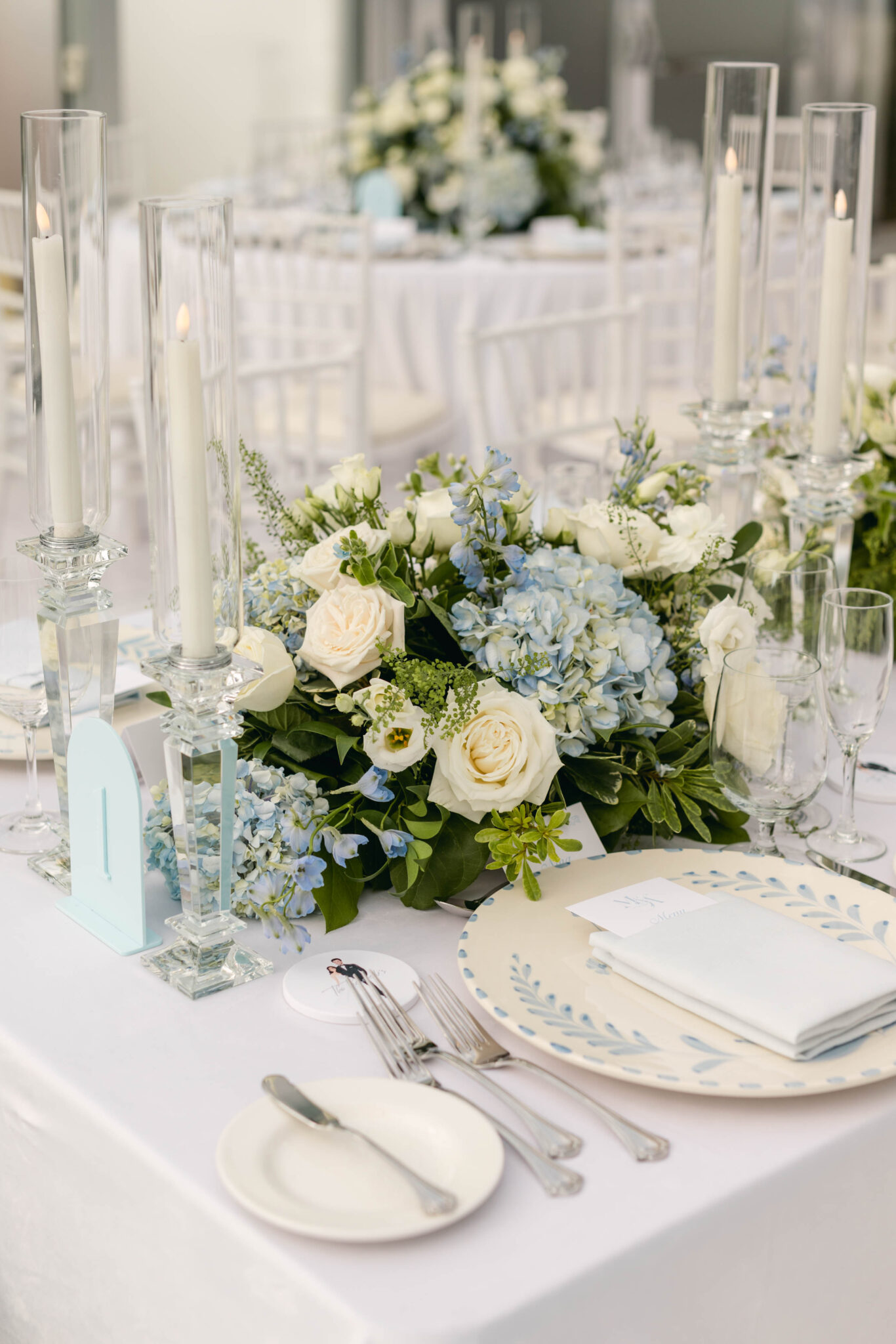 Elegant table setting with white and blue floral centerpiece, tall ...