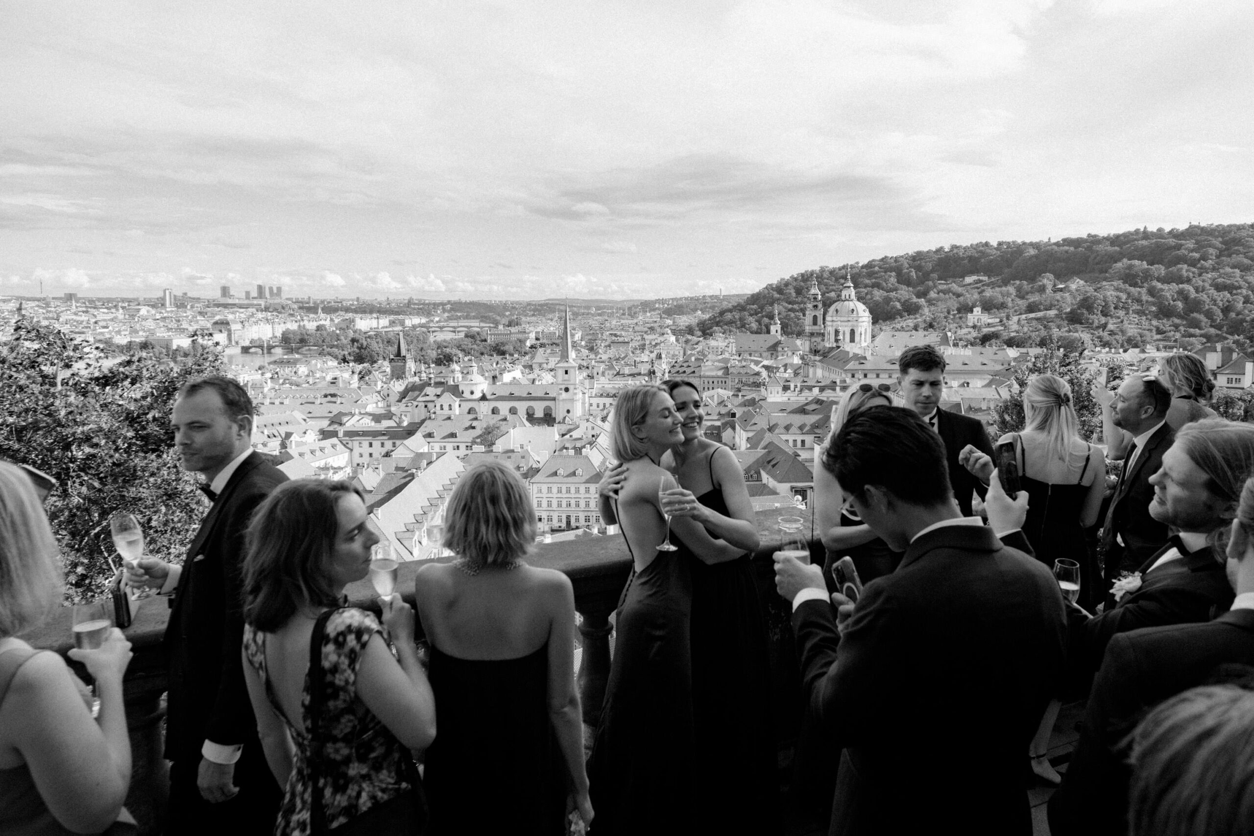 A group of elegantly dressed people in formal attire socialize with ...