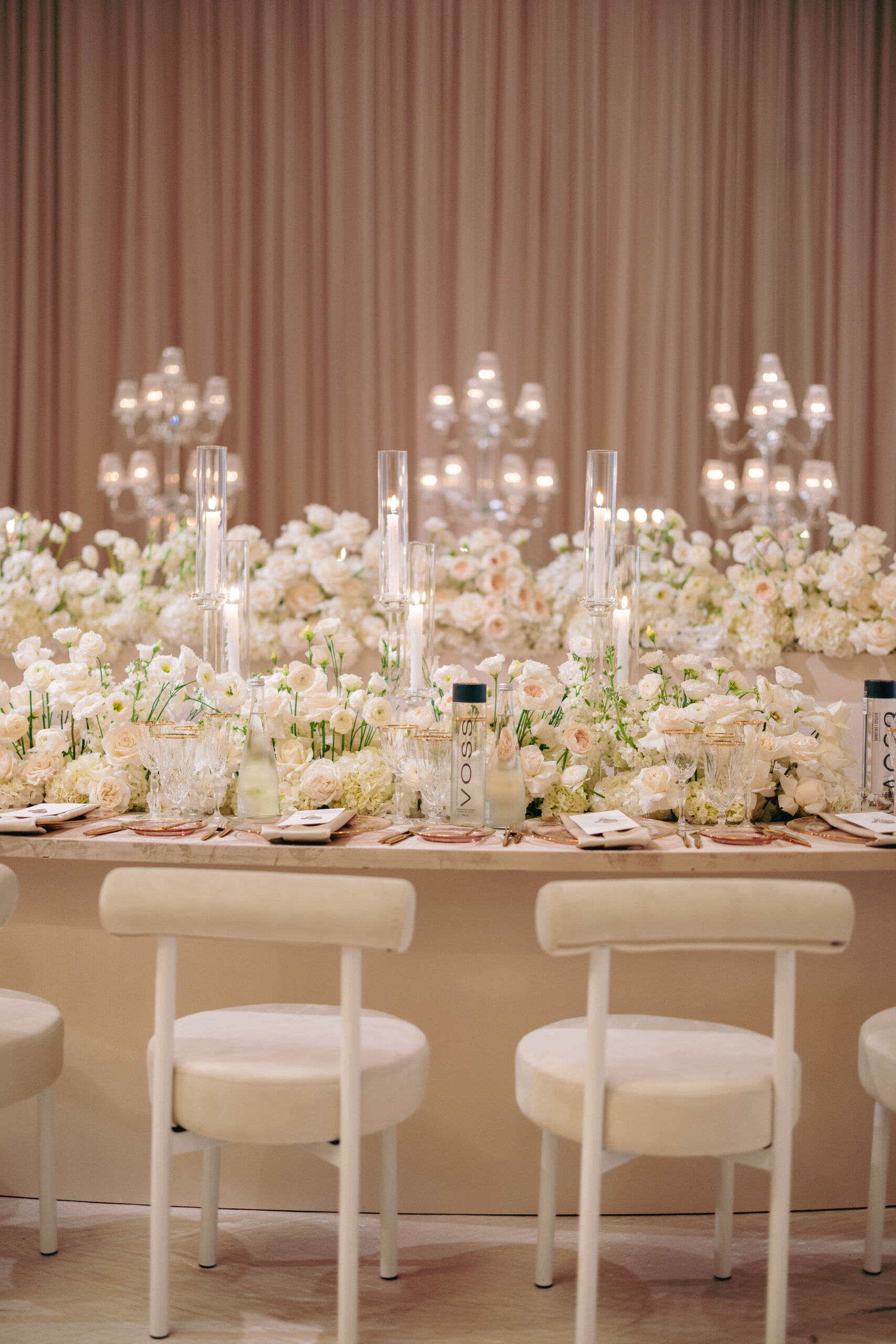 A beautifully decorated table set for an event, featuring white chairs ...