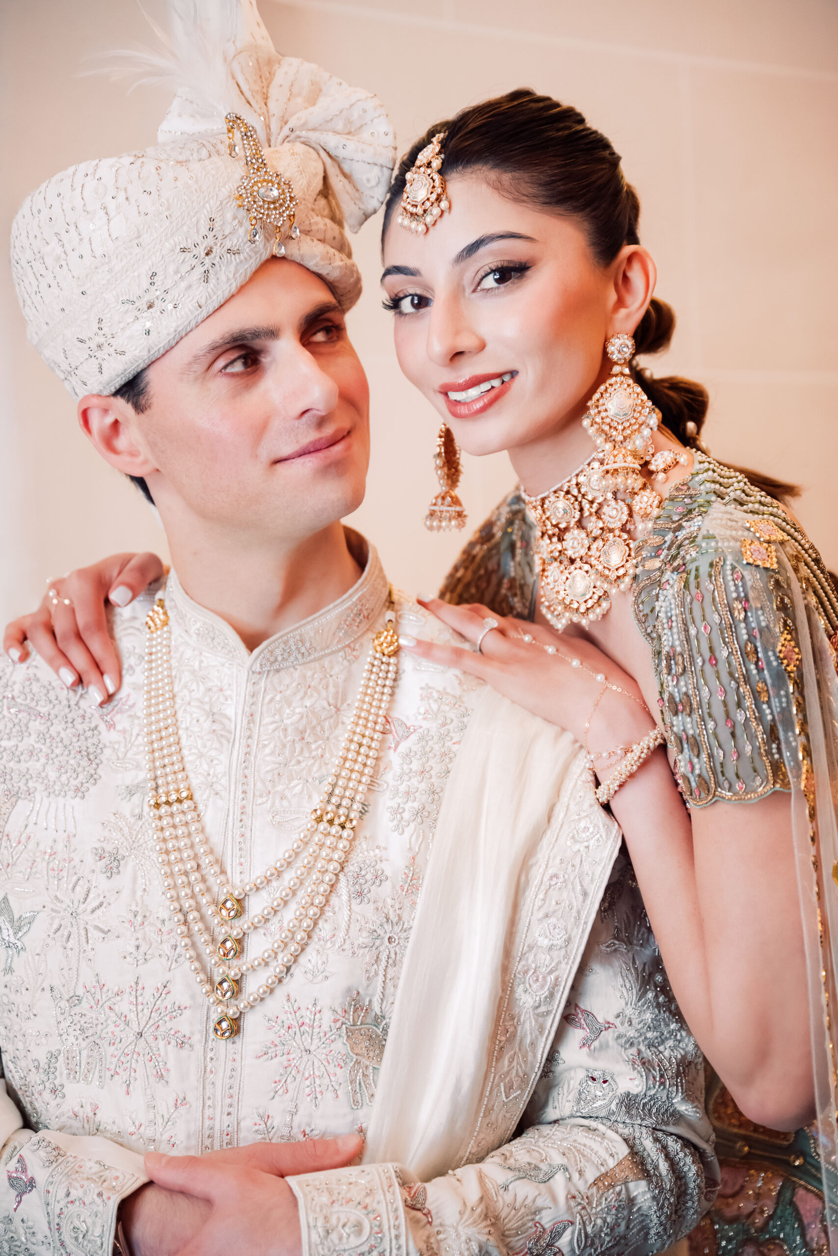 A bride and groom in ornate traditional South Asian wedding attire ...