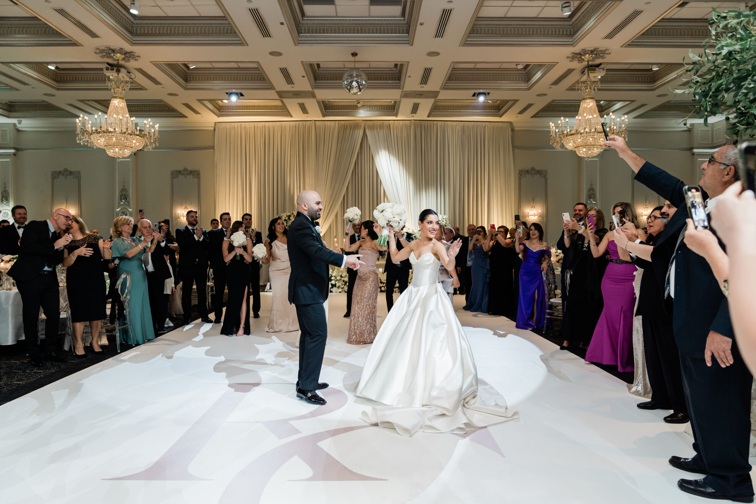 A newlywed couple shares their first dance in a grand ballroom wedding ...