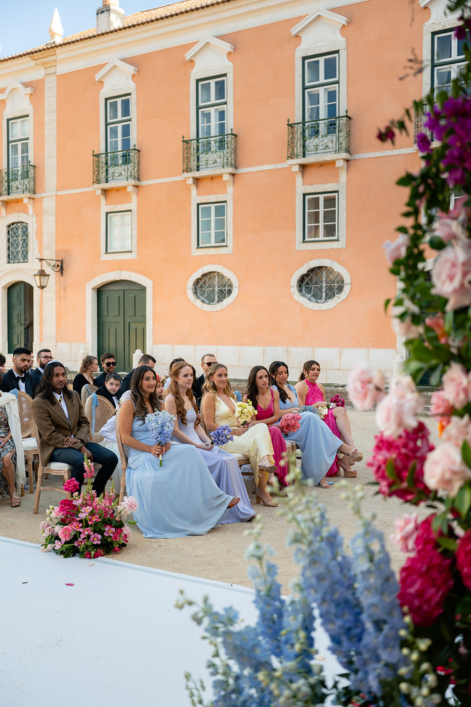 Guests seated outdoors at a Portugal destination wedding, with women in ...