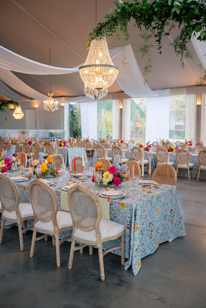 Elegant banquet hall with crystal chandeliers, floral tablecloths ...