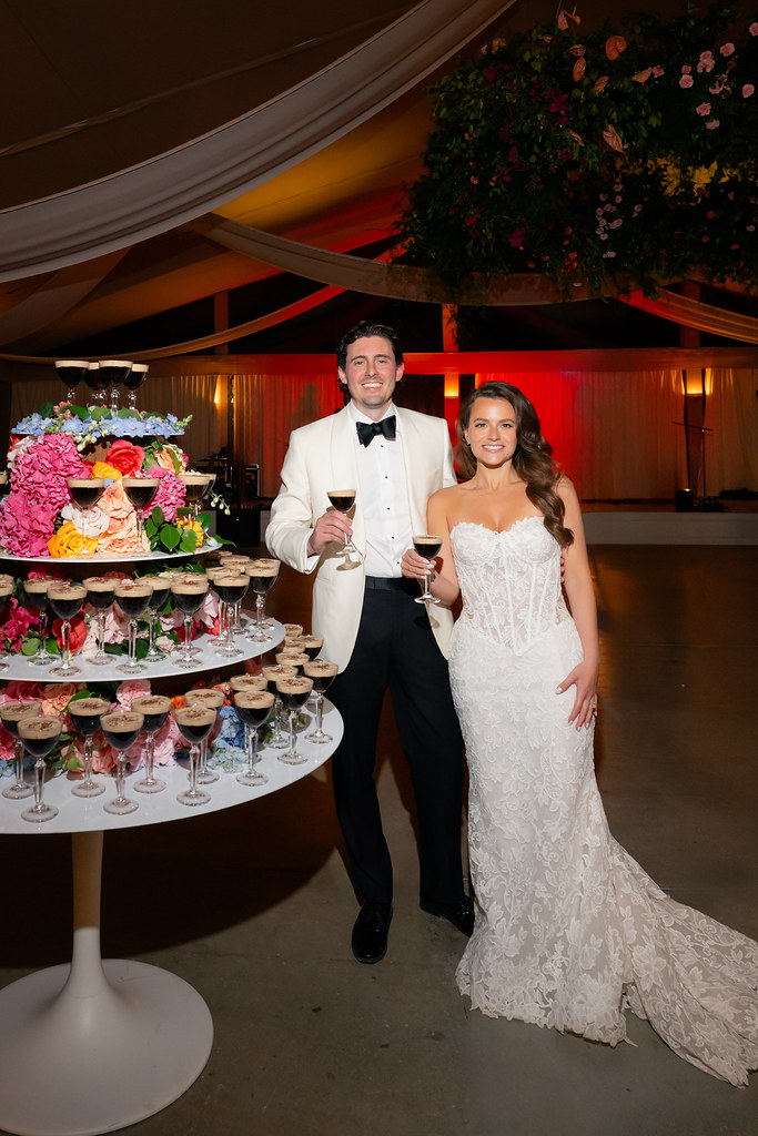 A bride in a white lace dress and a groom in a white tuxedo jacket ...