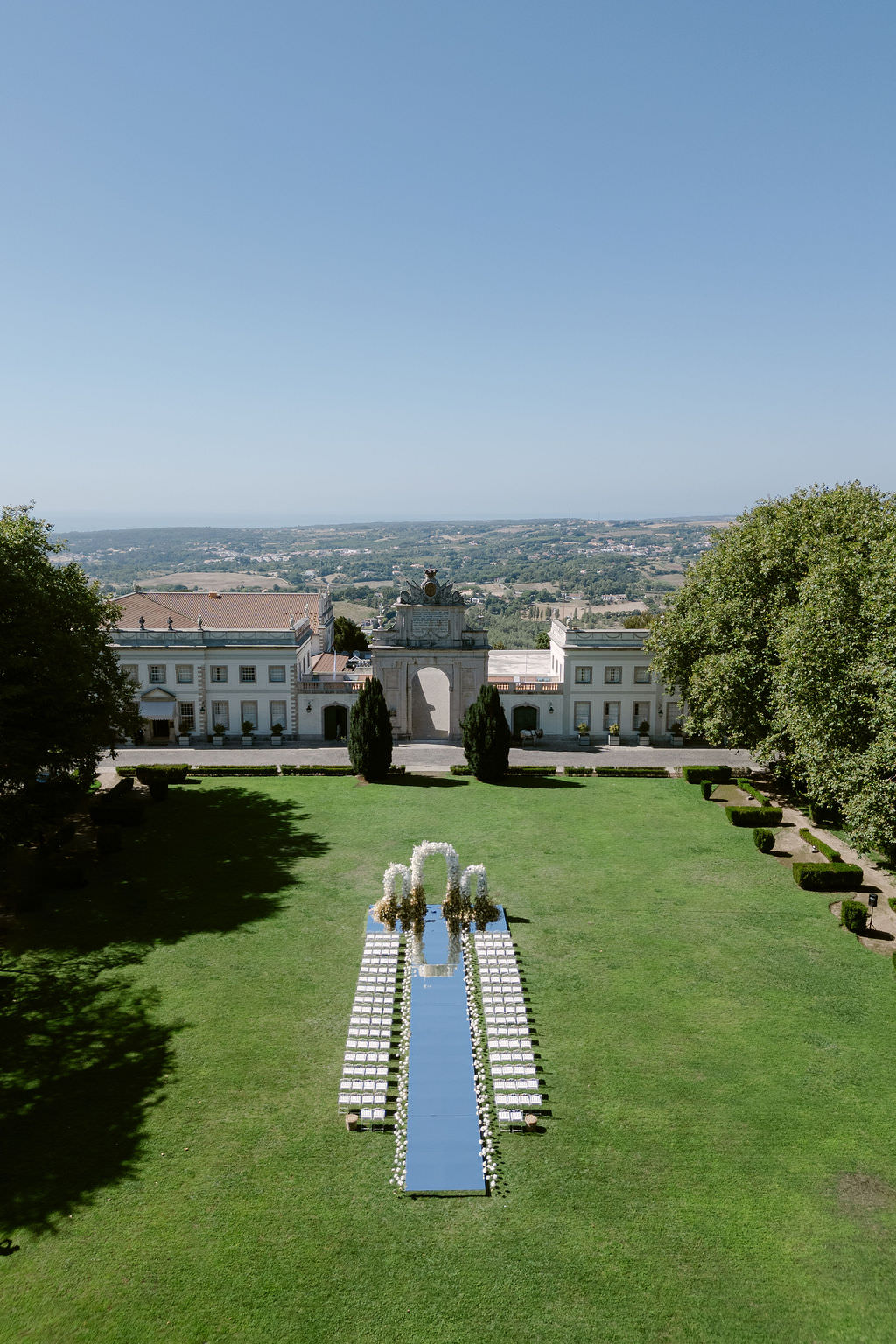 A large, elegant lawn set for a Portugal palace wedding features rows ...